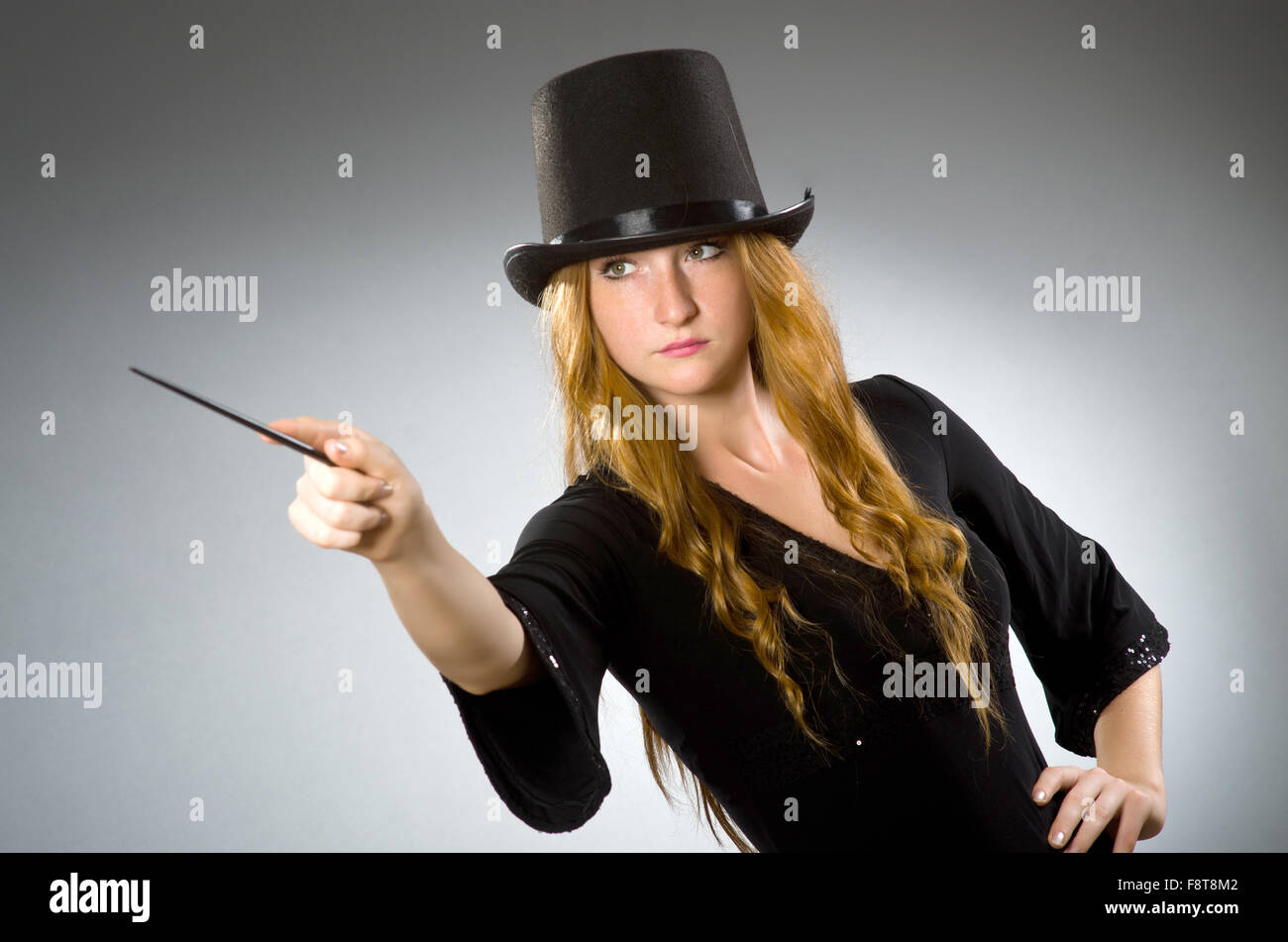 Woman magician doing her tricks with wand Stock Photo - Alamy