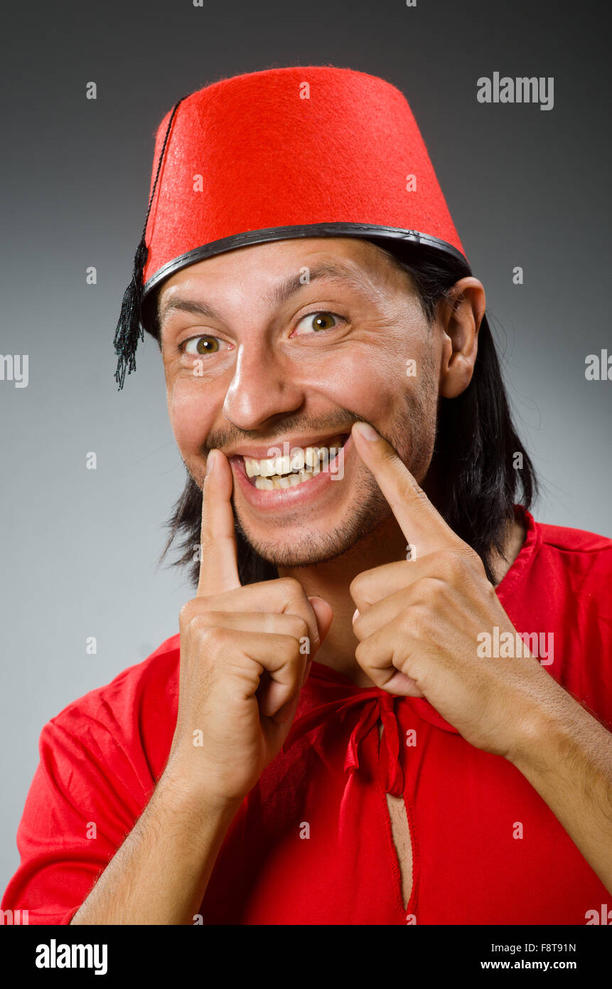 Funny man in red dress wearing fez hat Stock Photo - Alamy