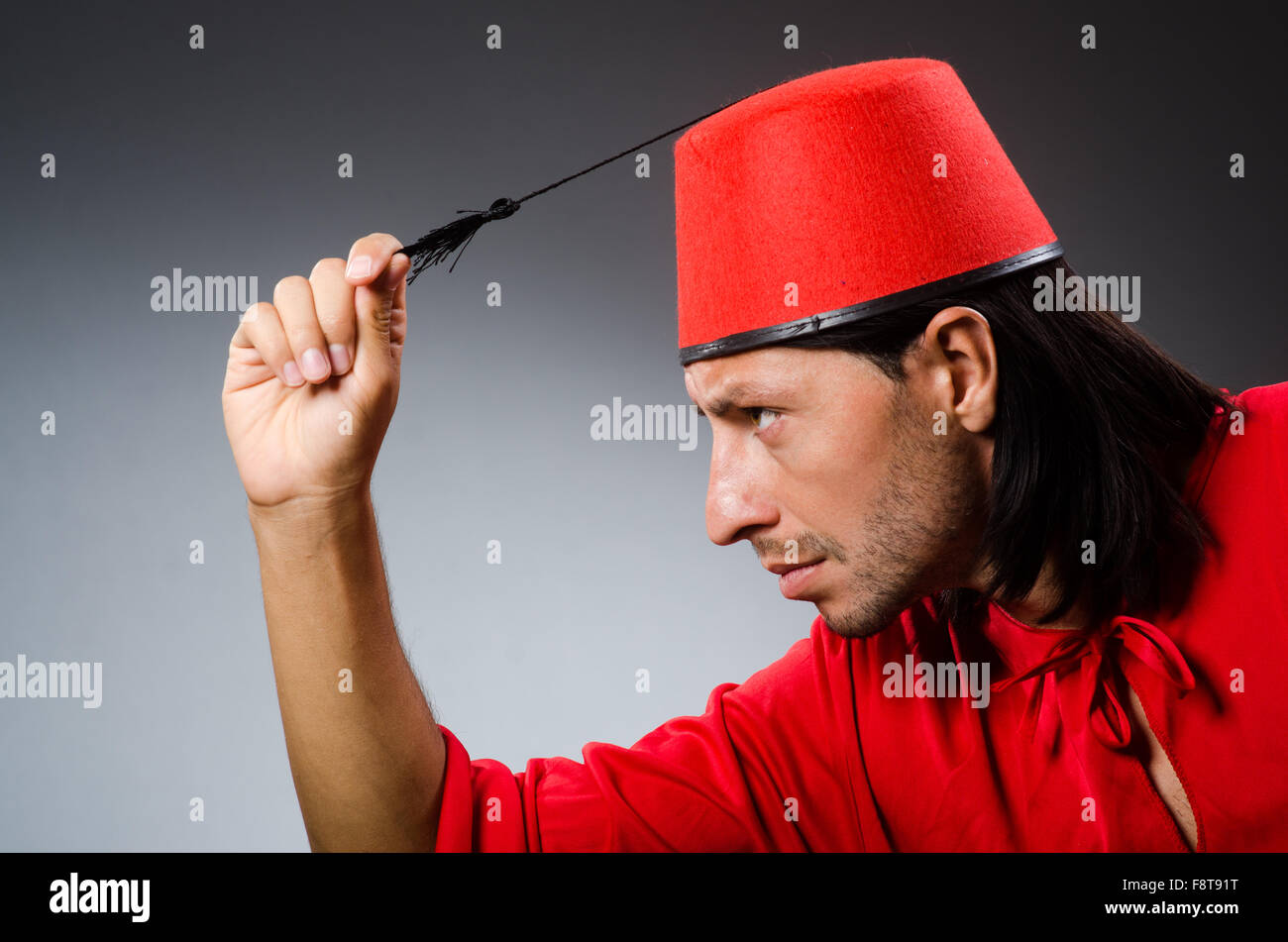 Funny man in red dress wearing fez hat Stock Photo - Alamy