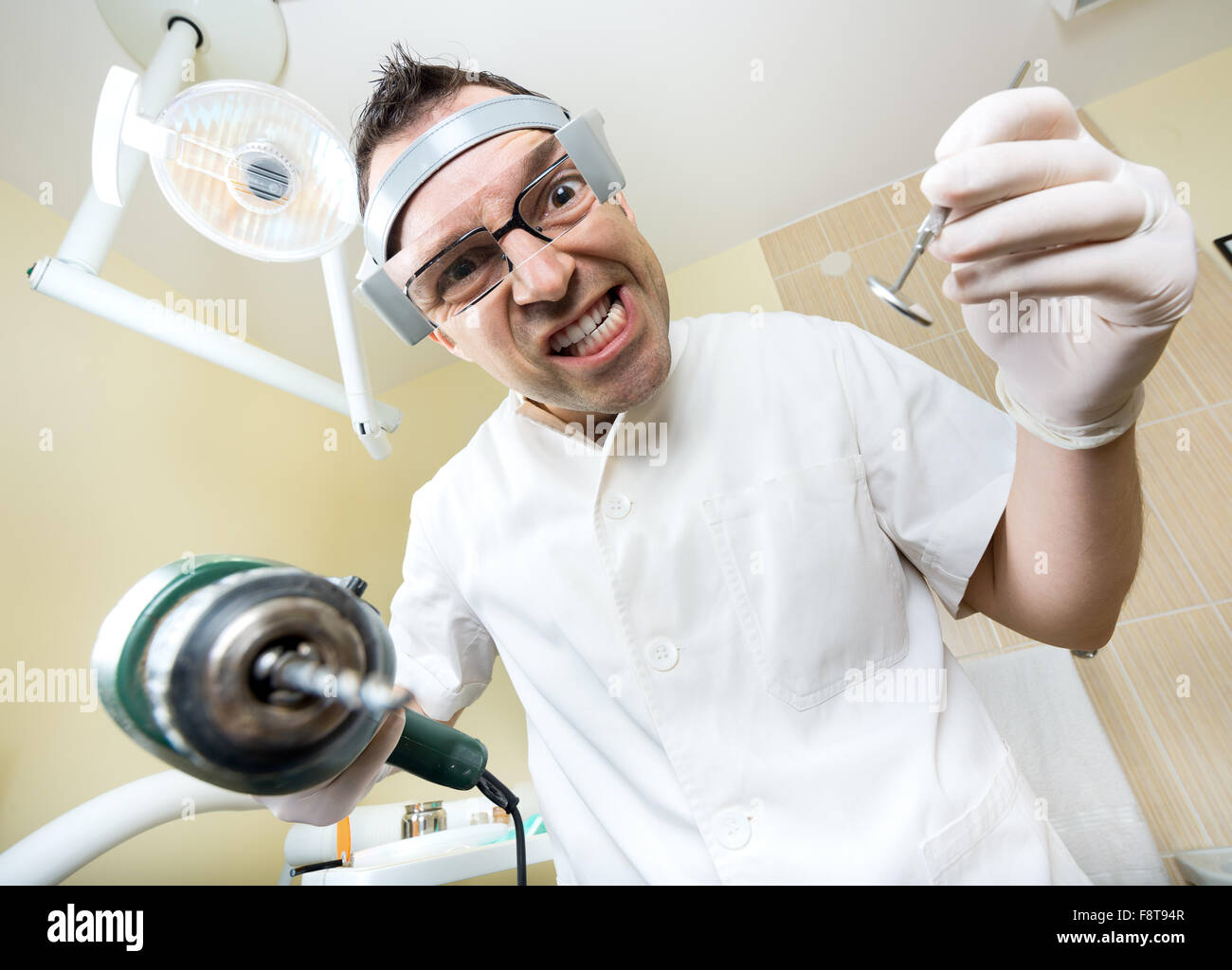 crazy dentist ready to drill approached the patient and dental ...