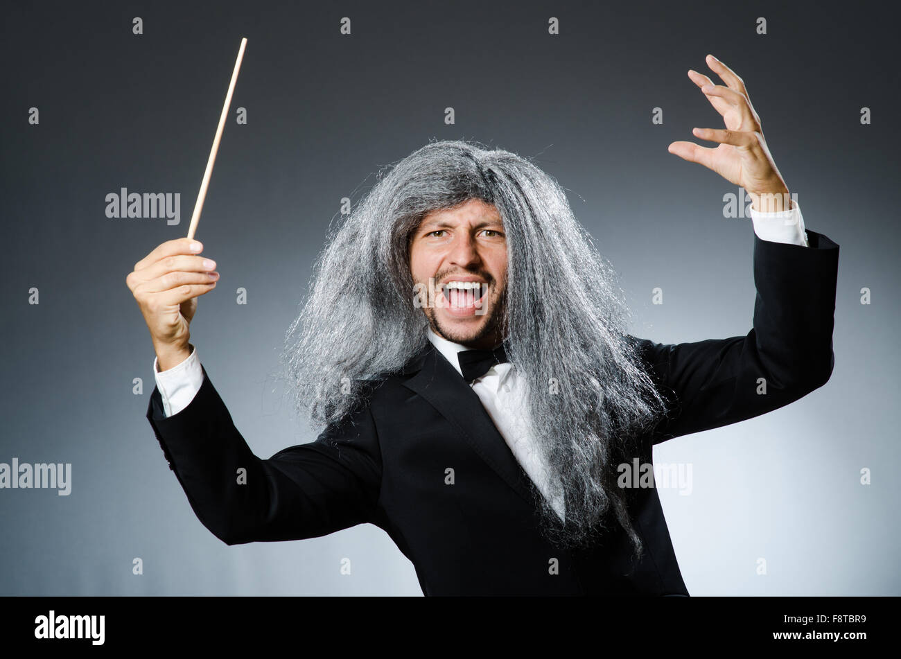 Funny conductor with long grey hair Stock Photo - Alamy