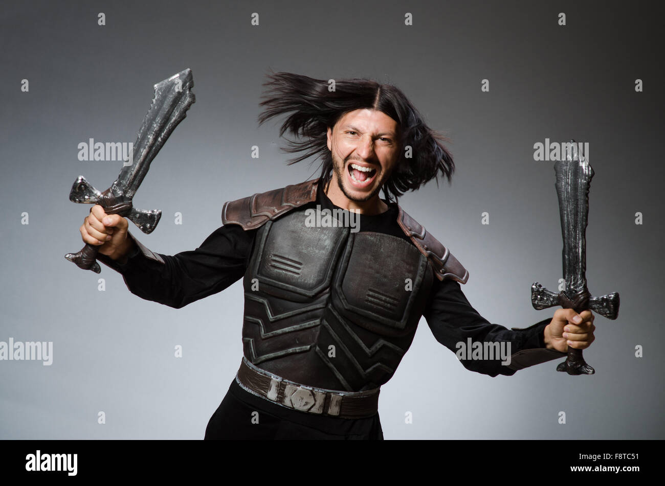 Angry knight with sword against dark background Stock Photo - Alamy