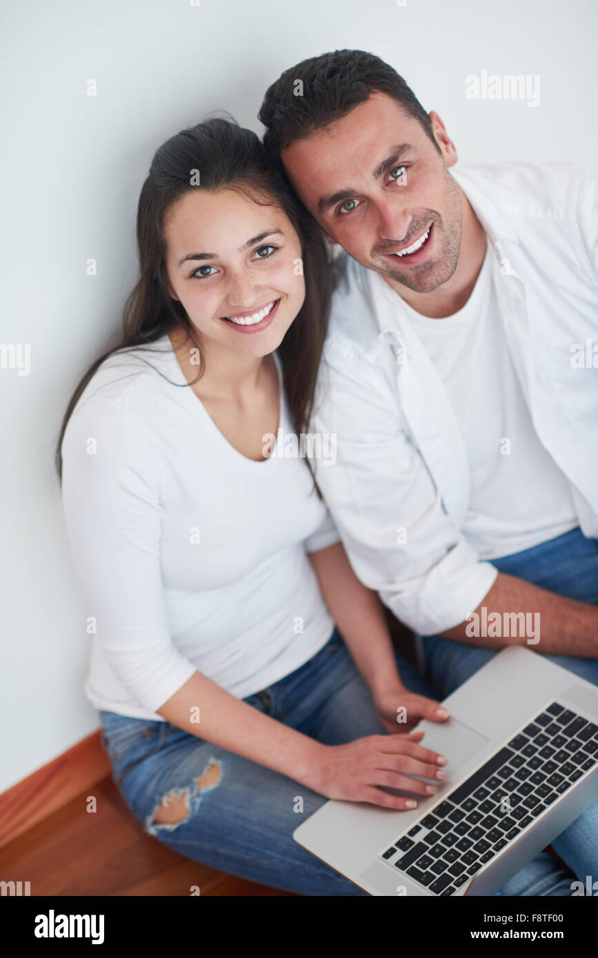 happy young relaxed couple working on laptop computer at modern home ...