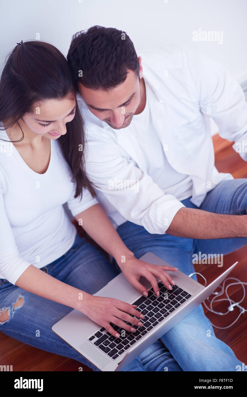 happy young relaxed couple working on laptop computer at modern home ...