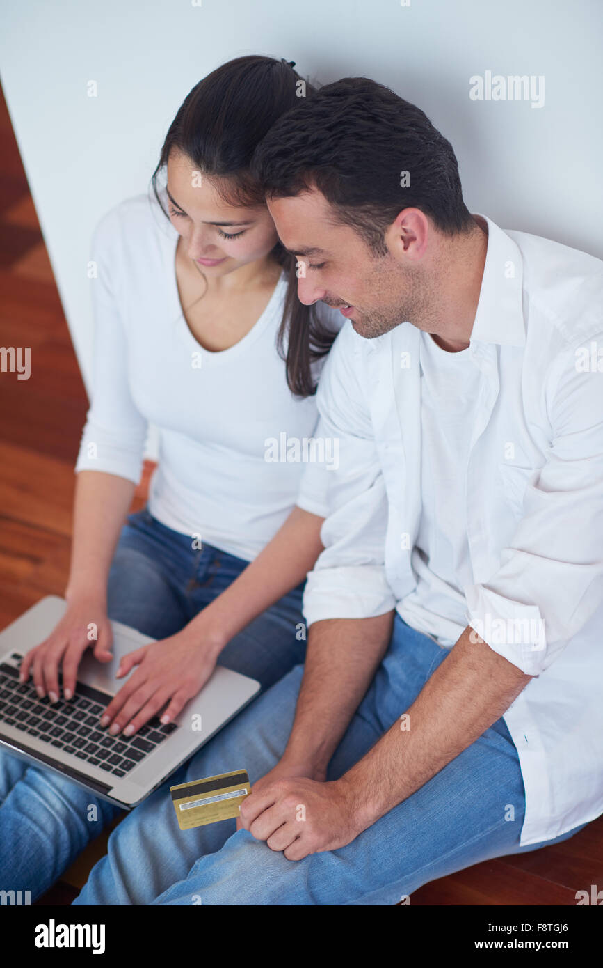 happy young relaxed couple working on laptop computer at modern home ...