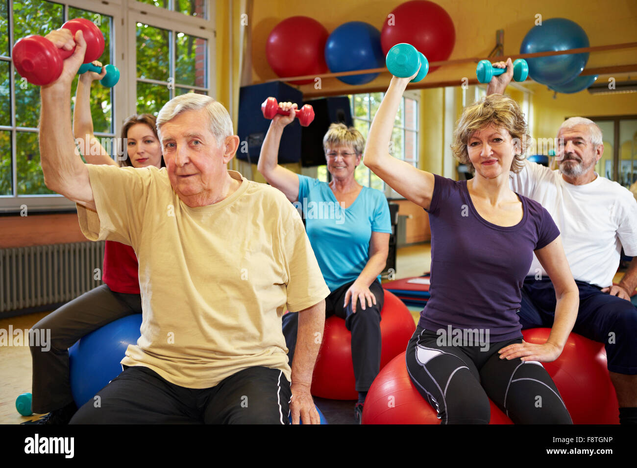 Group working out with dumbbells in gym Stock Photo - Alamy