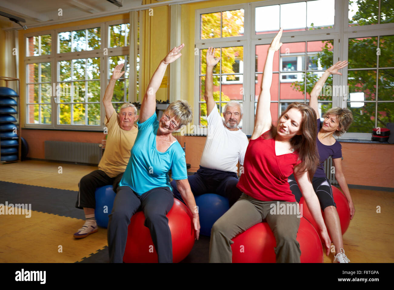 Mixed group doing back exercises in a gym Stock Photo - Alamy