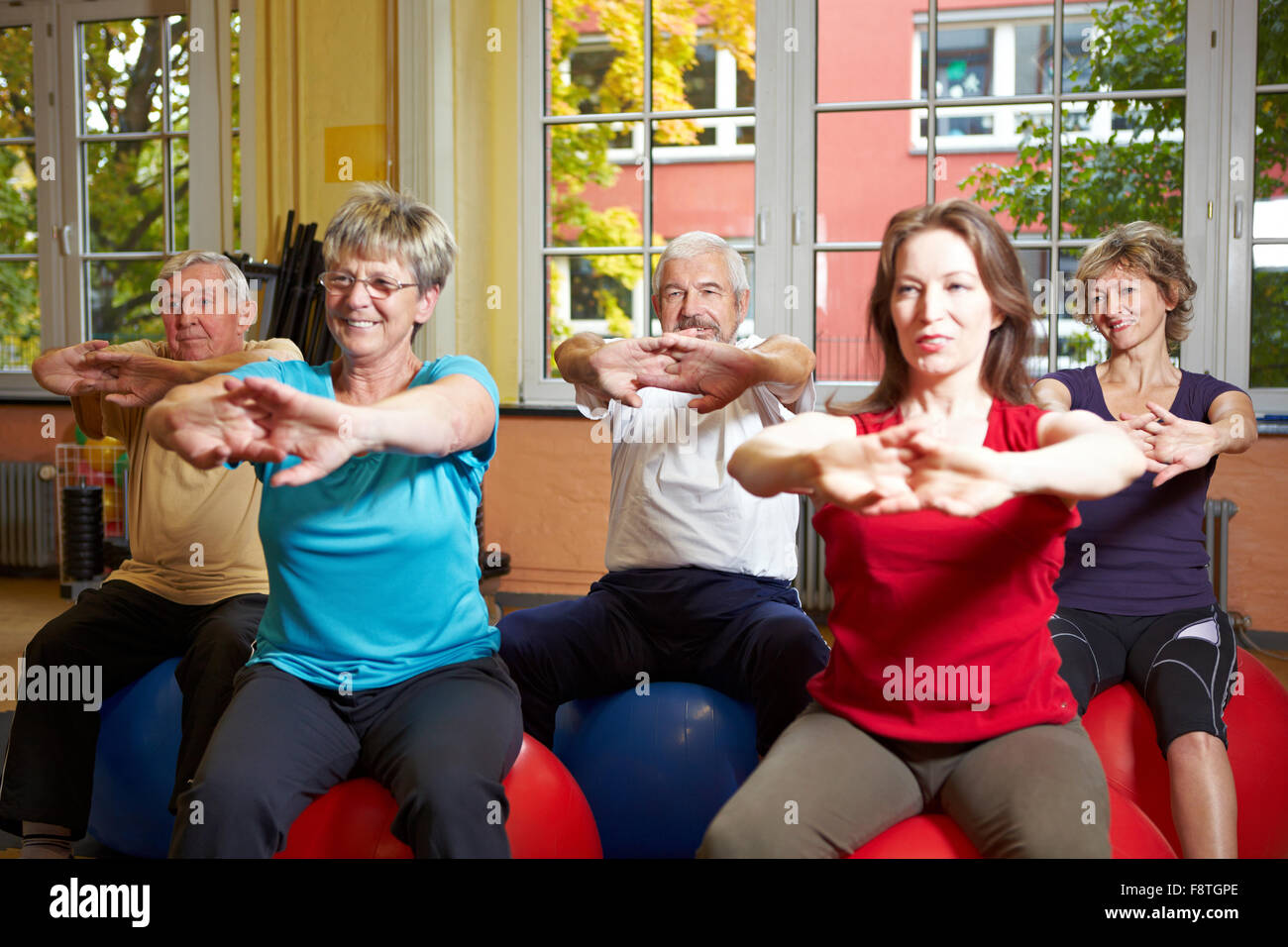 Mixed group doing back exercises in a gym Stock Photo - Alamy