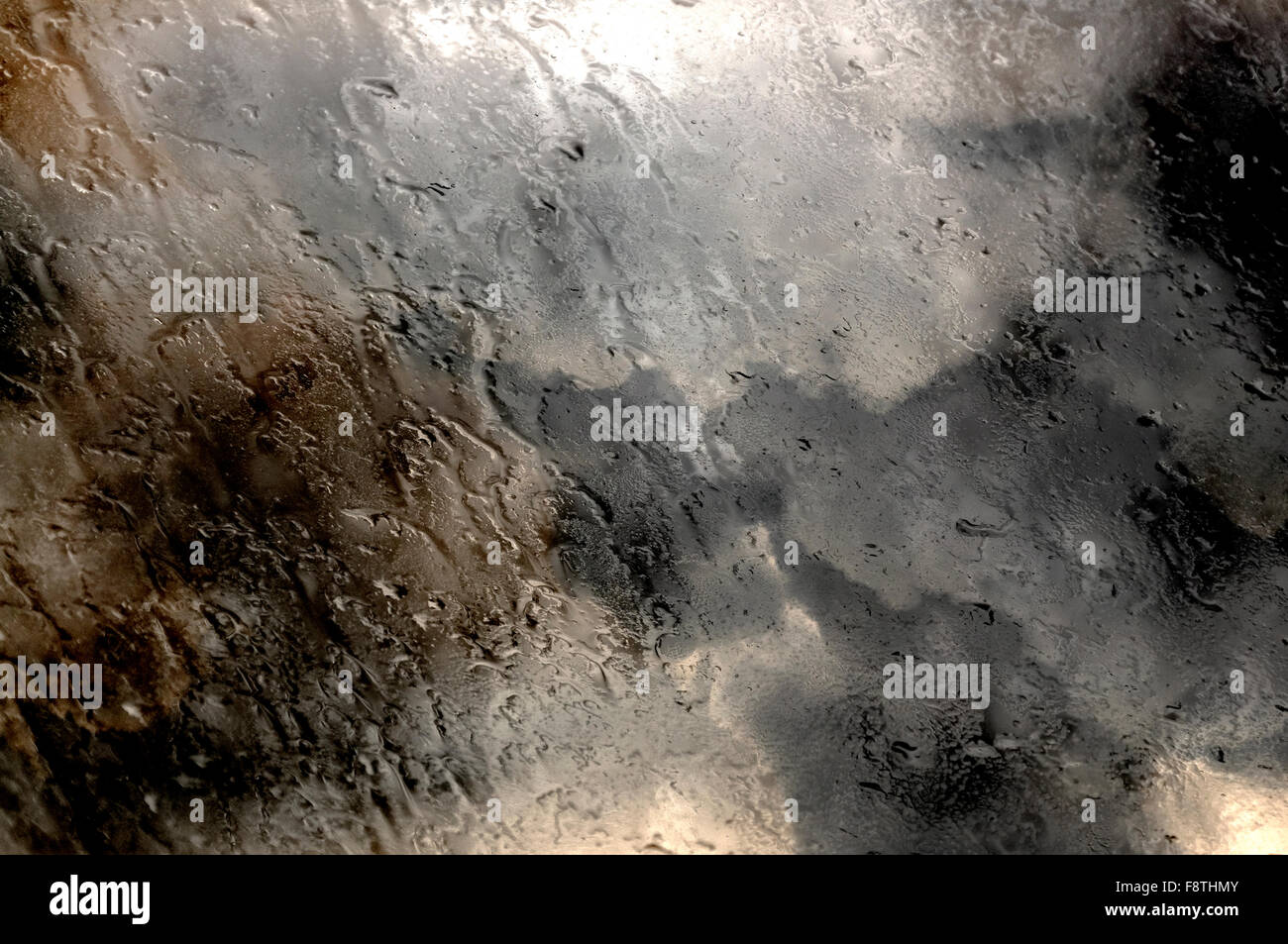 raindrops and dark clouds of a stormy weather covering sky, low light ...