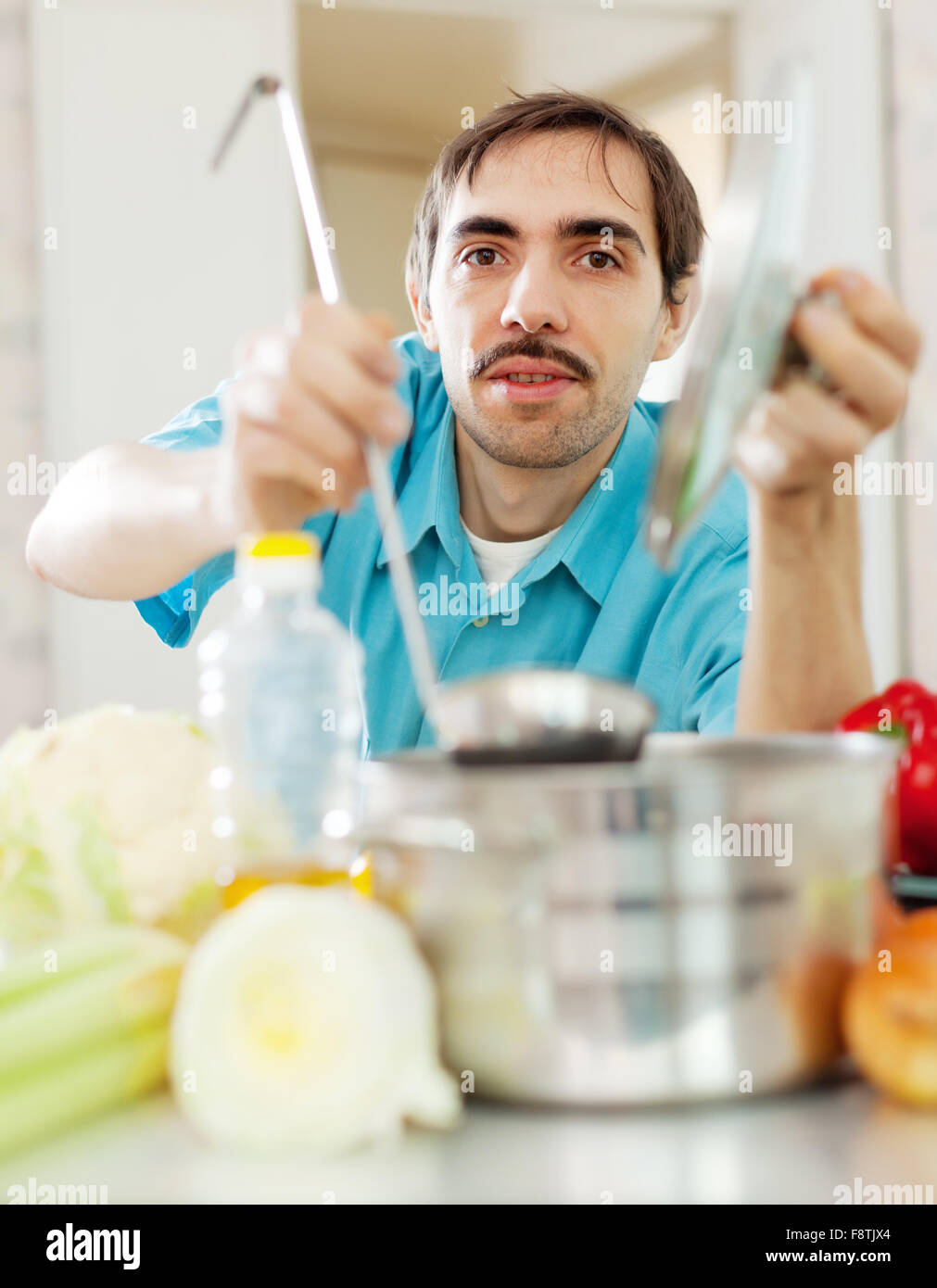 Handsome man cooks soup hi-res stock photography and images - Alamy