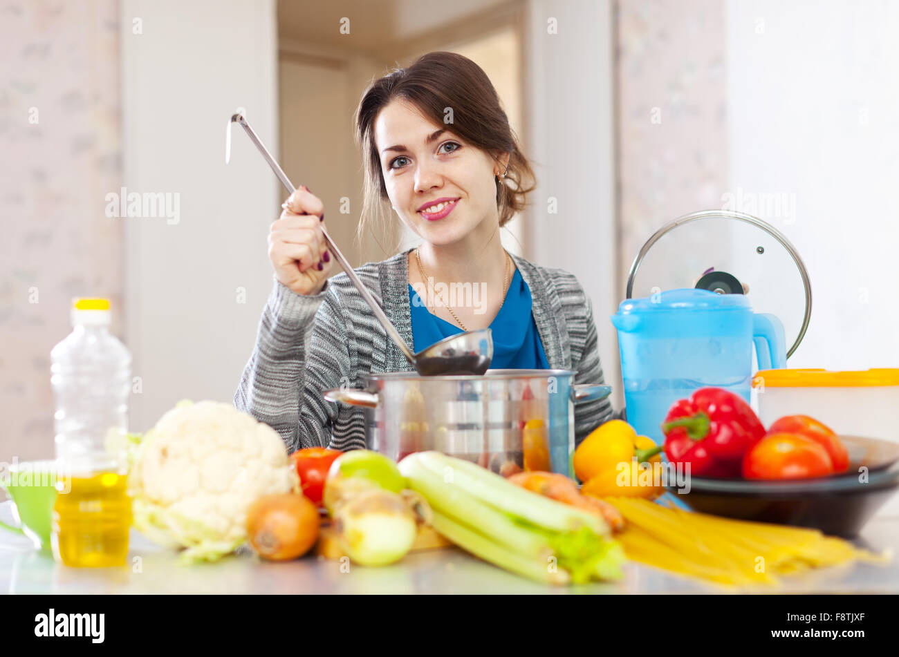 woman cooking veggie soup with laddle in kitchen Stock Photo - Alamy