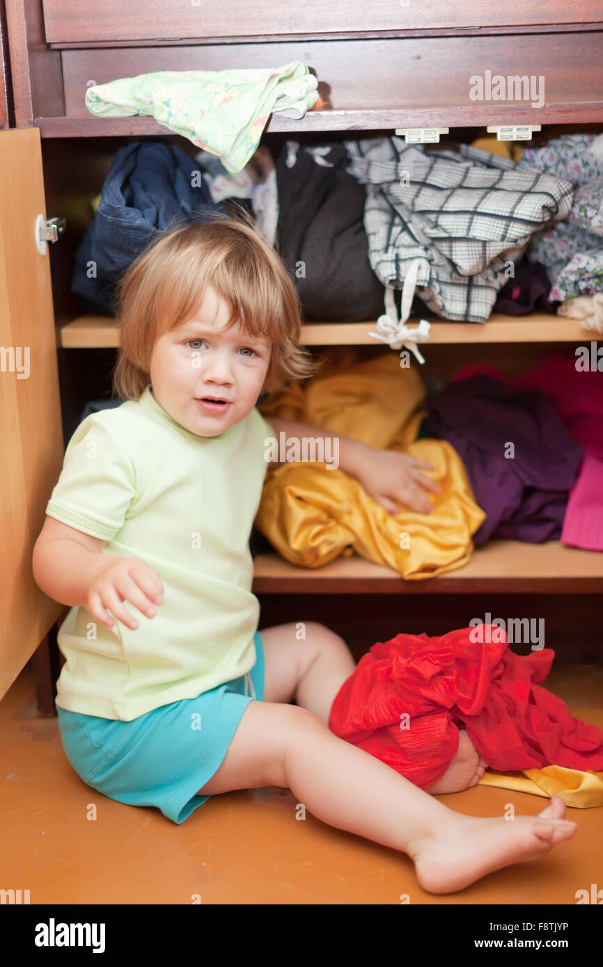 Baby girl chooses dress in parent's closet Stock Photo - Alamy