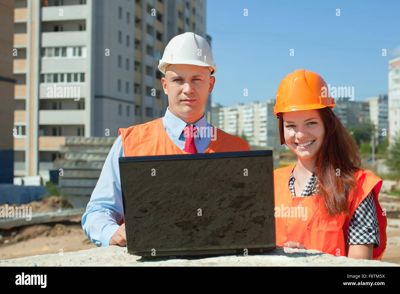 two builders wearing protective helmet works on the building site Stock ...