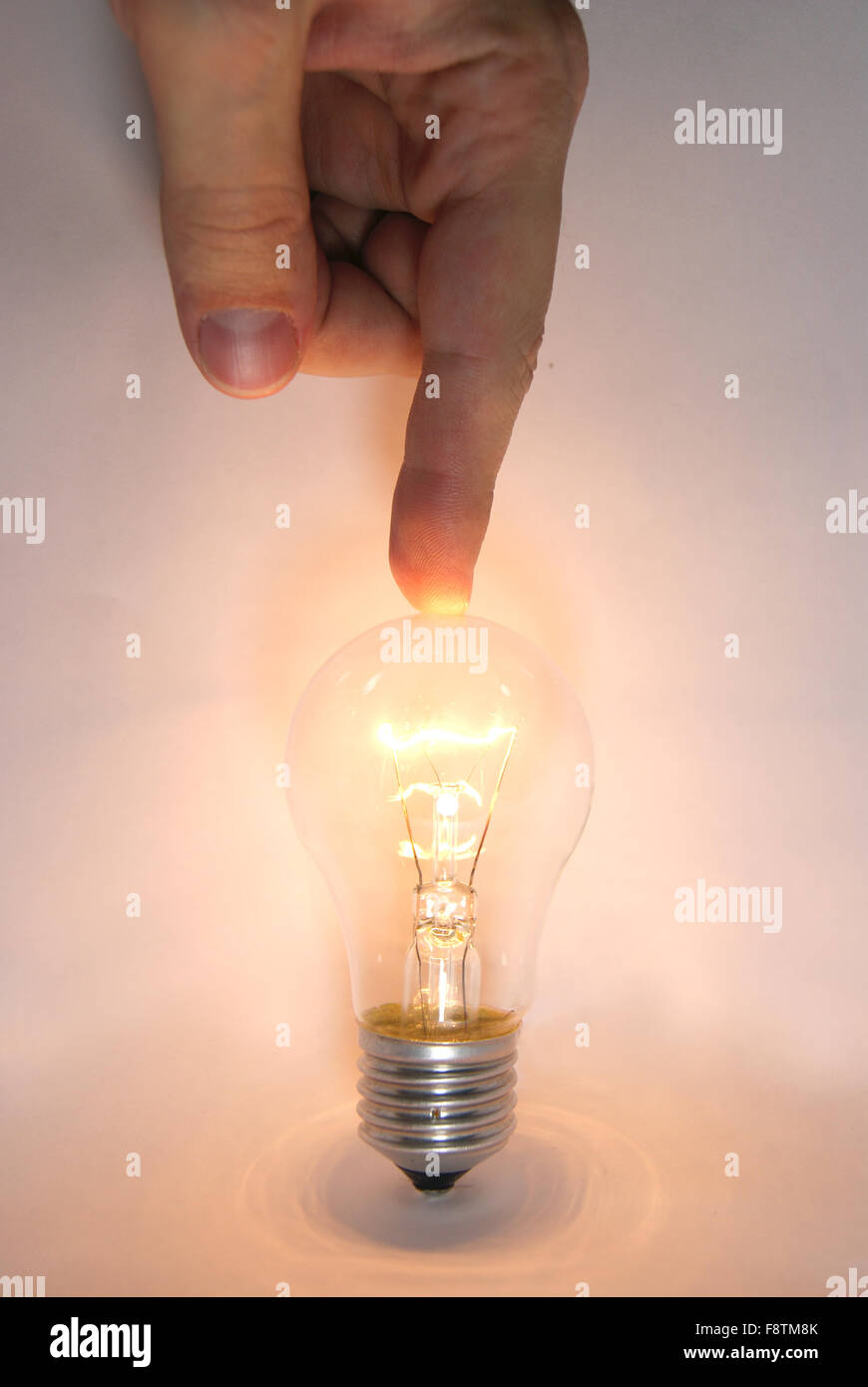 Human hand points a finger at the lamp on white background new idea ...