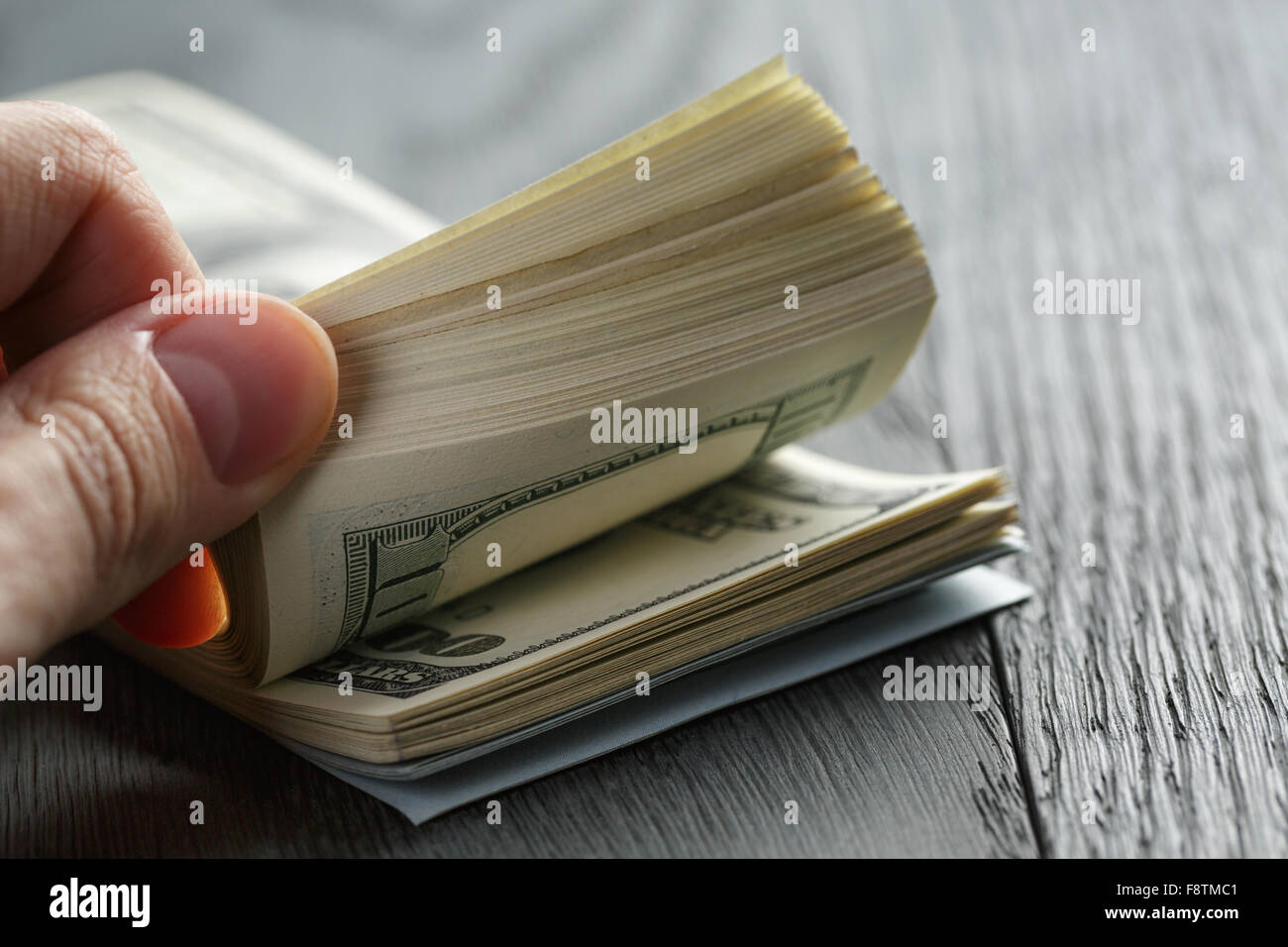 man hands counting dollar notes on wood table Stock Photo - Alamy