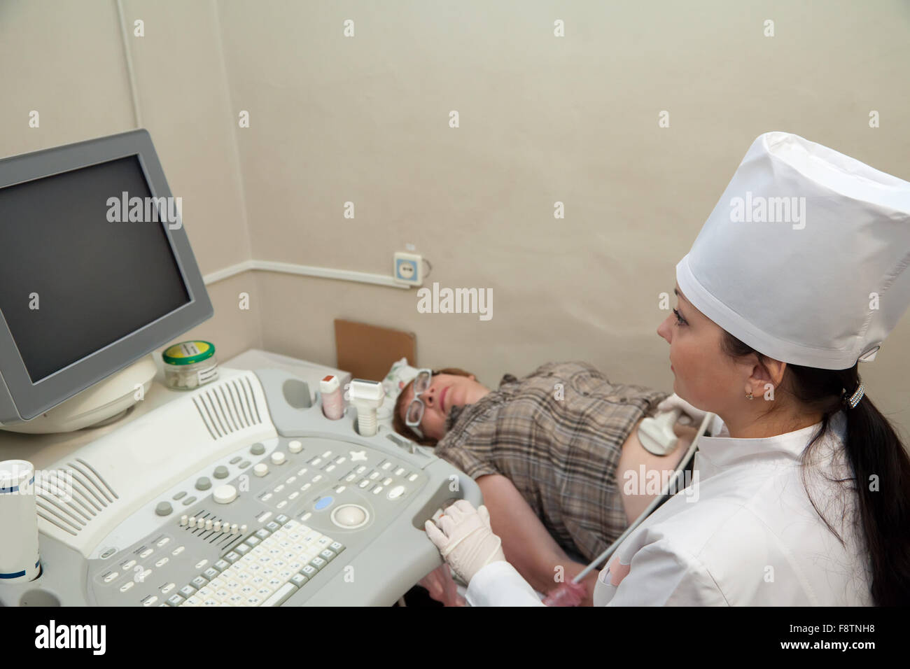 Female doctor making ultrasound investigation in medical clinic Stock ...