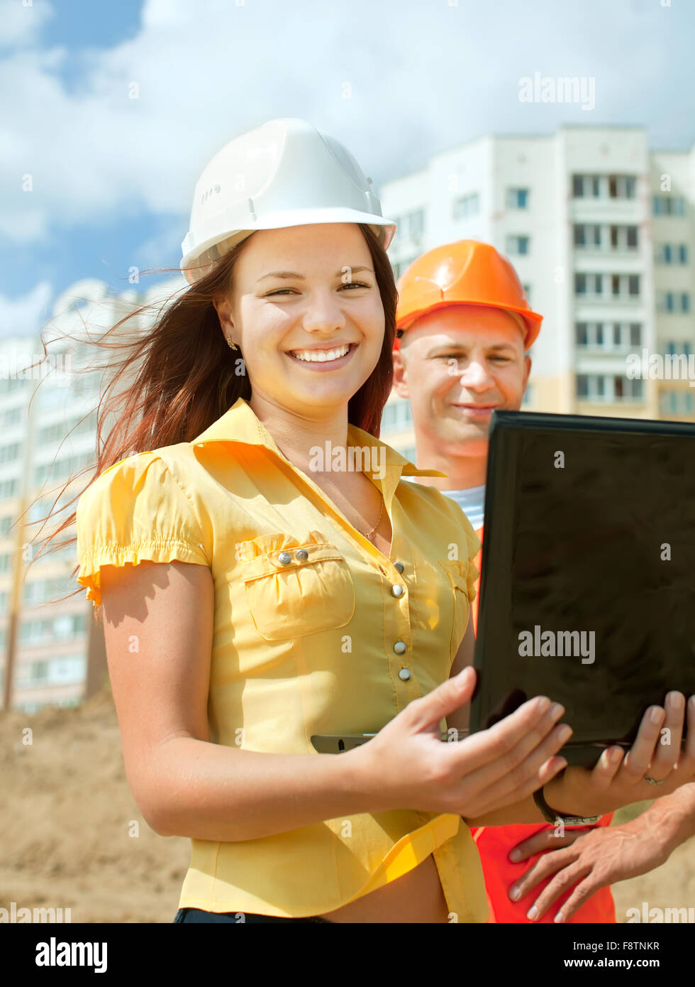 Portrait of two builders standing at building site Stock Photo - Alamy