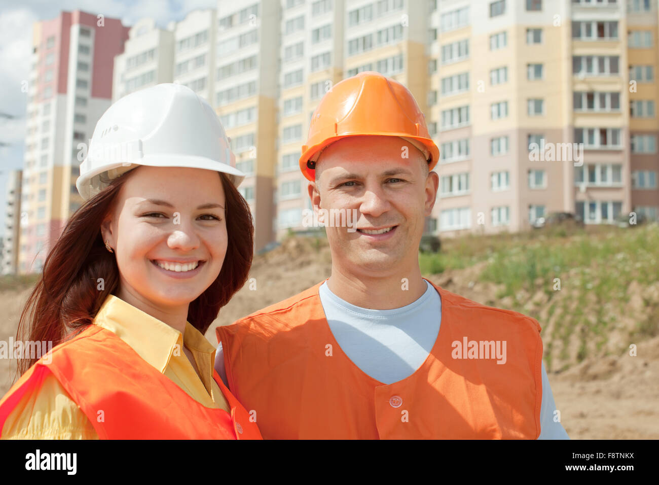 two happy builders in hardhat works on the building site Stock Photo - Alamy