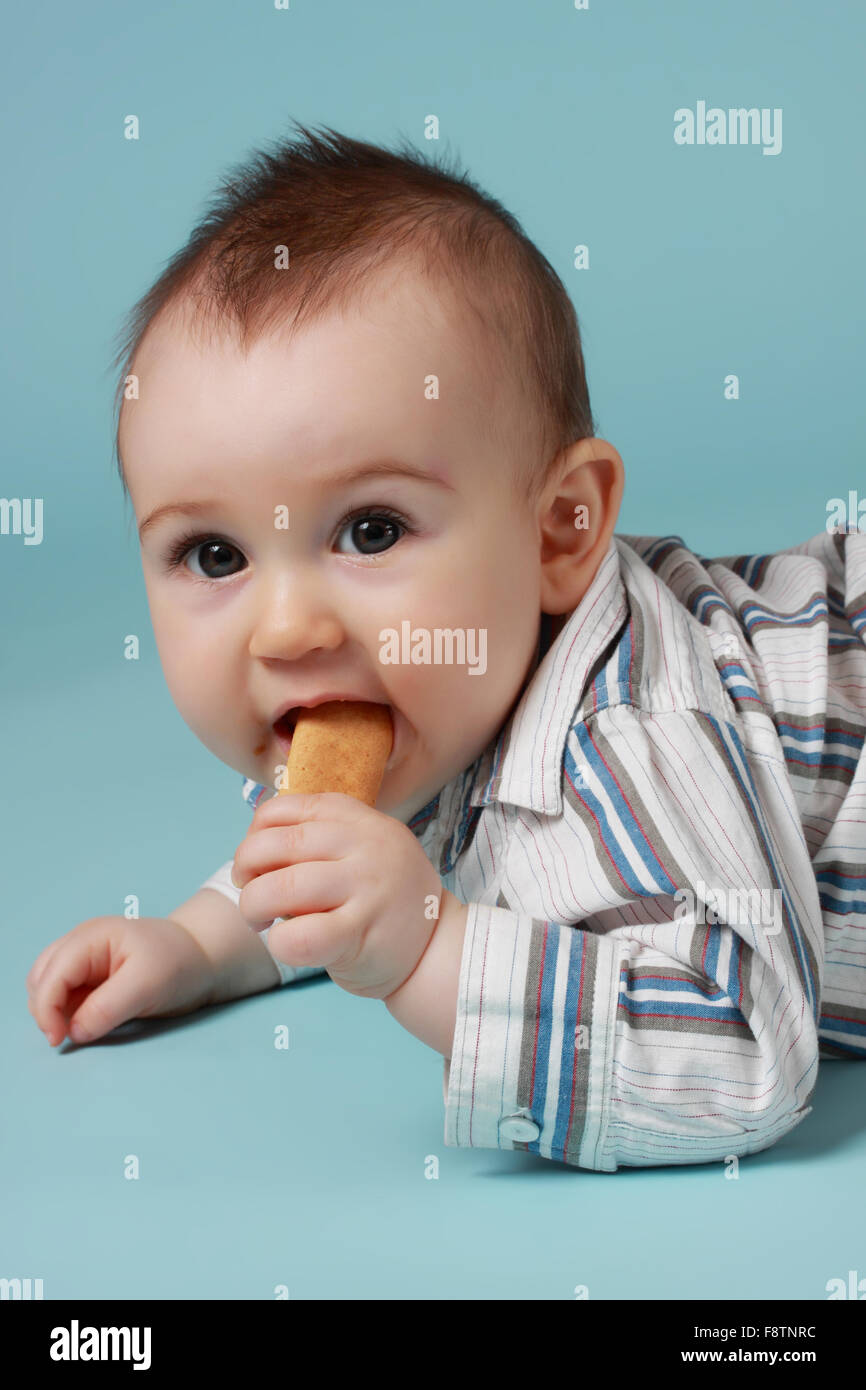 baby boy eating a cookie Stock Photo - Alamy