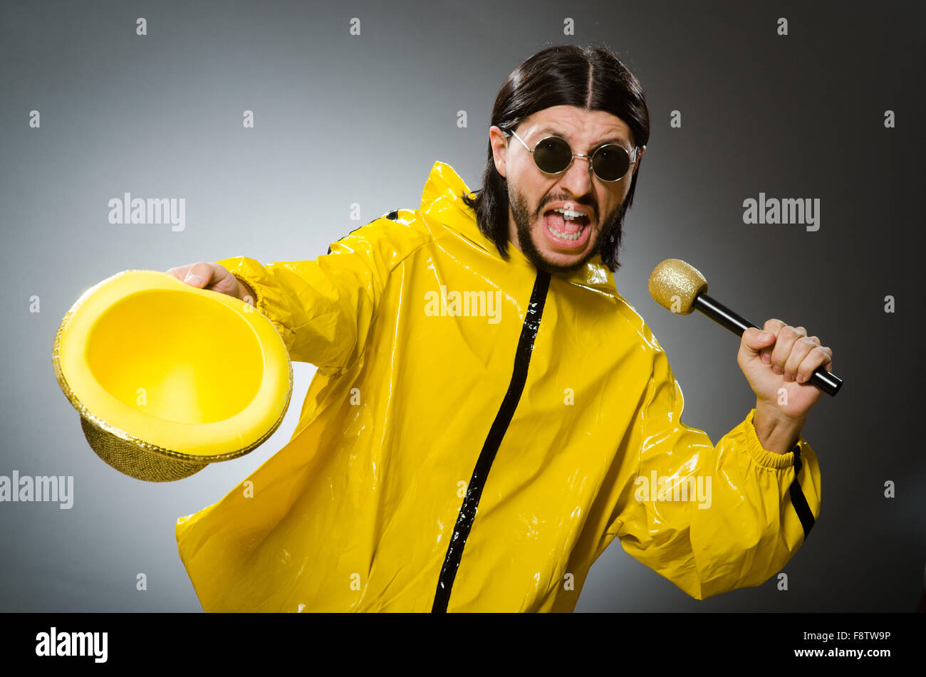 Man wearing yellow suit with mic Stock Photo - Alamy