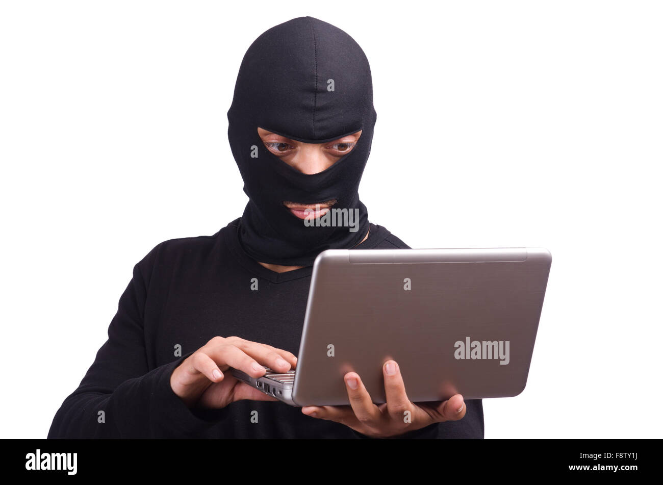 Hacker with computer wearing balaclava Stock Photo - Alamy