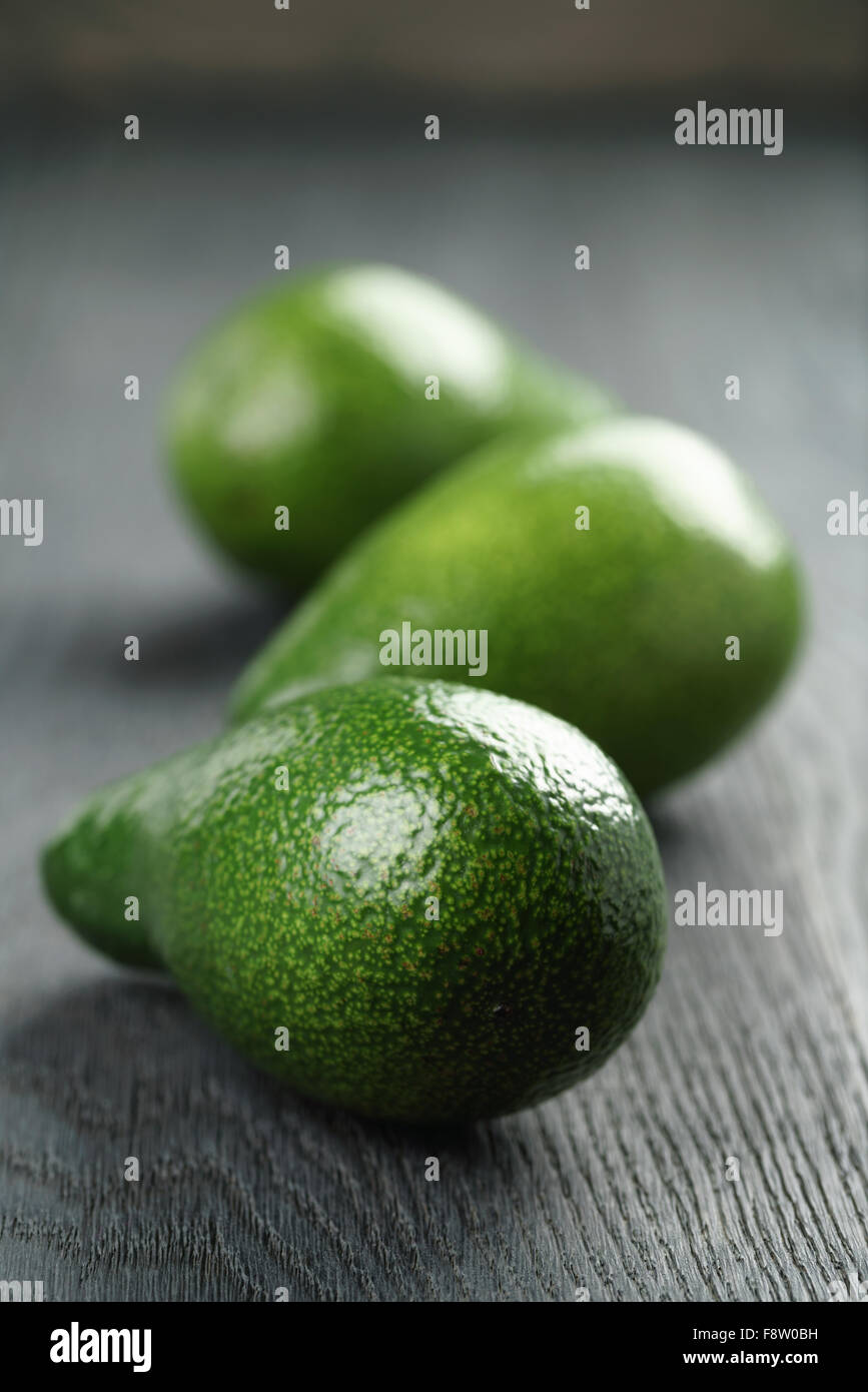 ripe green avocados on wood table Stock Photo - Alamy