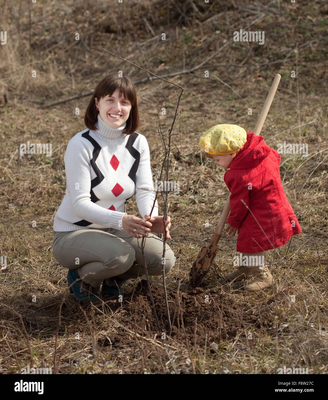 Mother and her baby girl planting tree Stock Photo - Alamy