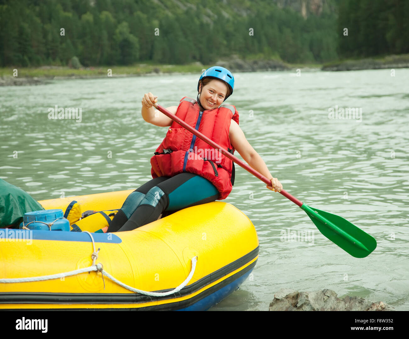 Girl with a paddle on the raft Stock Photo - Alamy