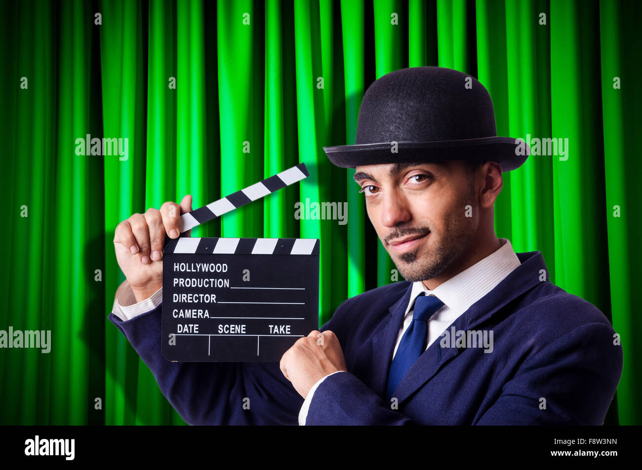 Man with movie clapper on curtain background Stock Photo - Alamy