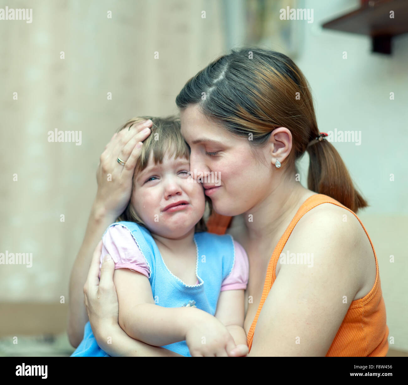woman soothes crying daughter. Focus on woman Stock Photo - Alamy