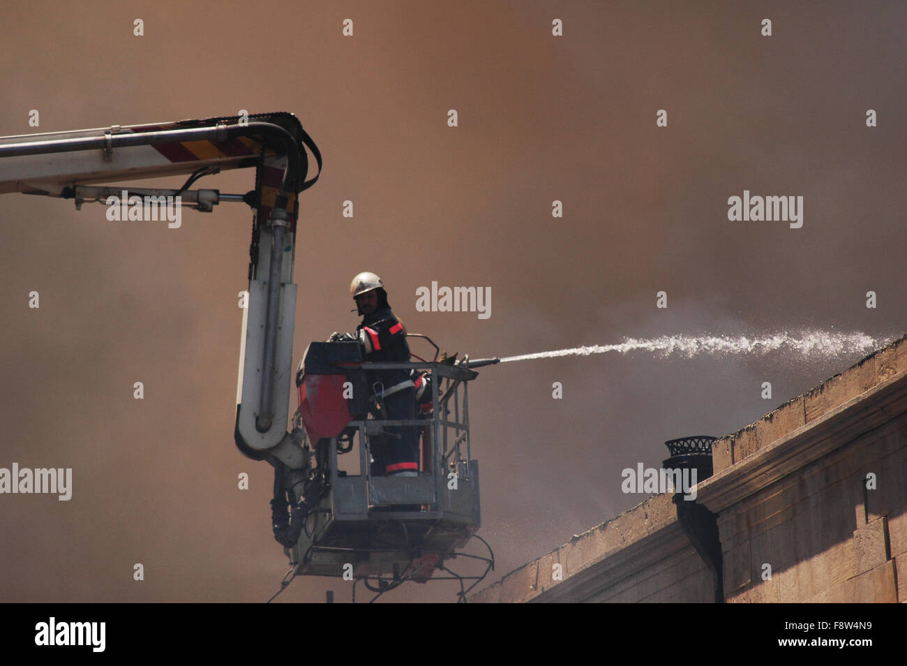 Firefighter on a boom during fire Stock Photo - Alamy