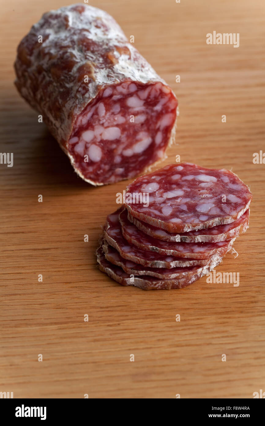 slices of an a italian salami on an oak table Stock Photo - Alamy