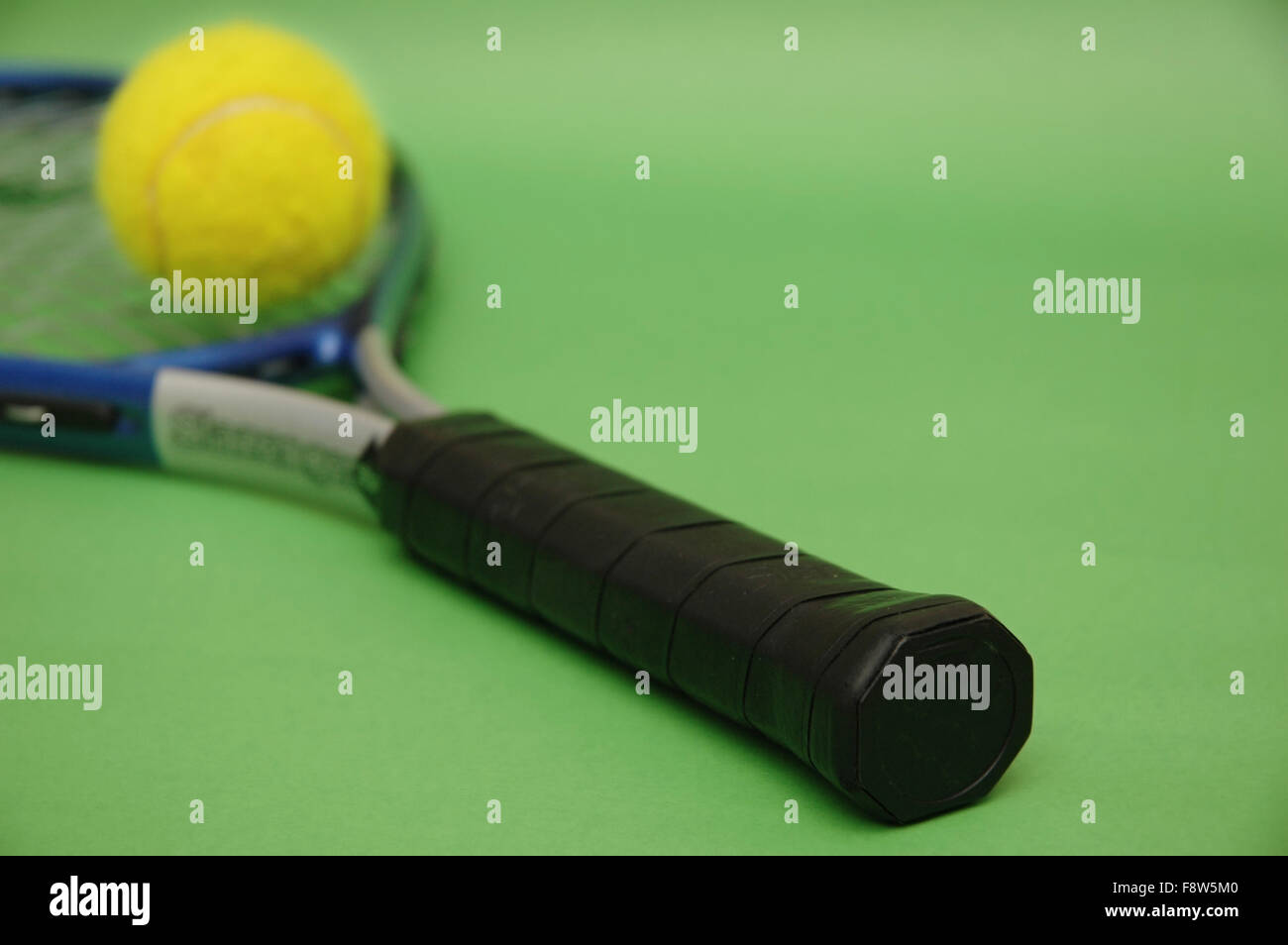 Tennis racket and ball on green background Stock Photo - Alamy
