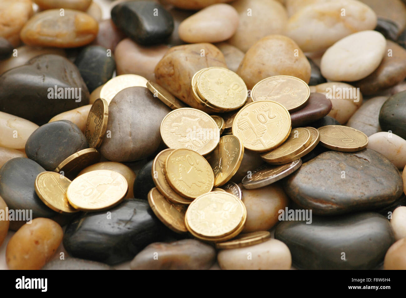 Various coines and pebbles at the background Stock Photo - Alamy