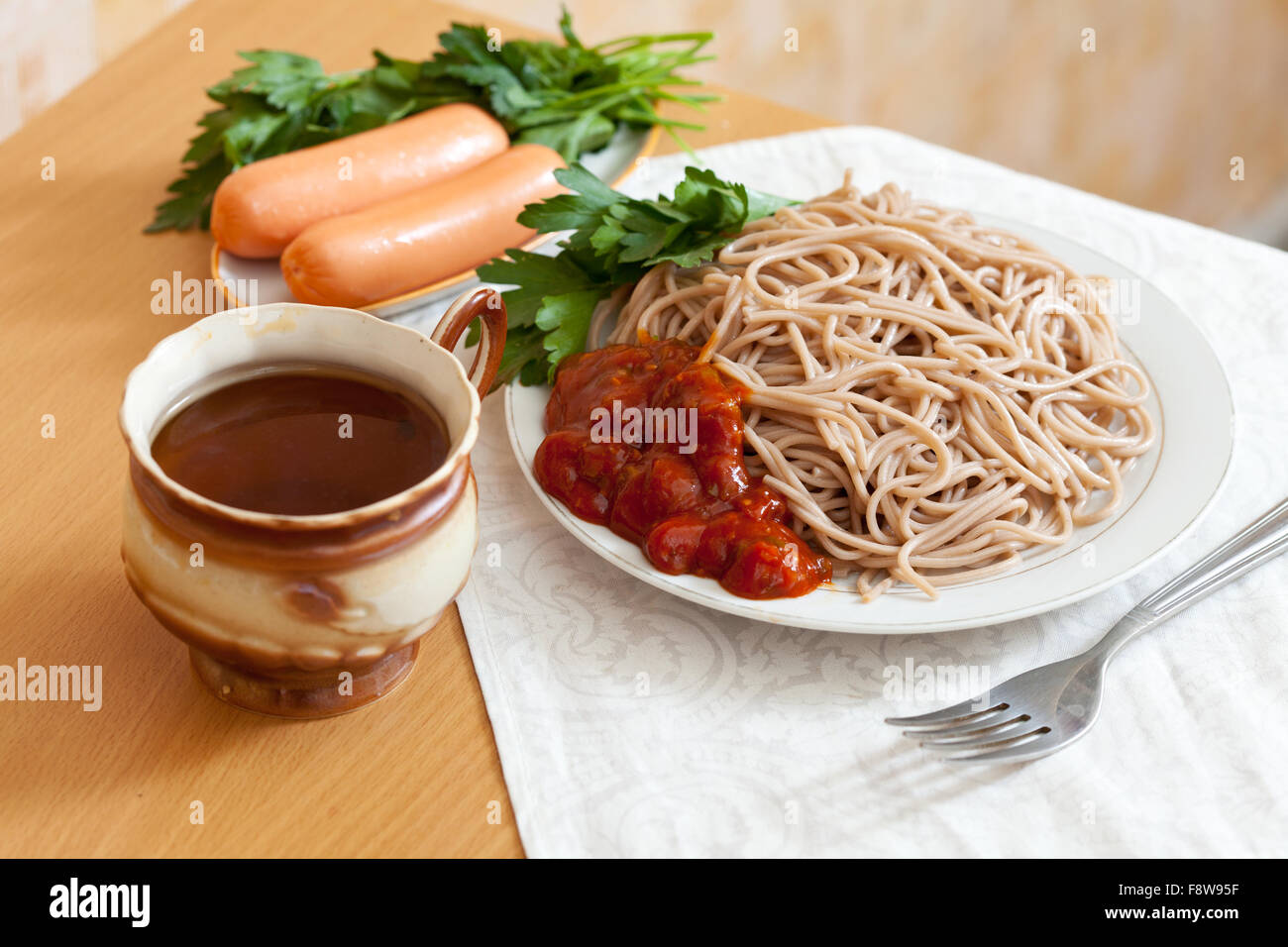 spaghetti pasta and sausages with cup of tea at home Stock Photo - Alamy