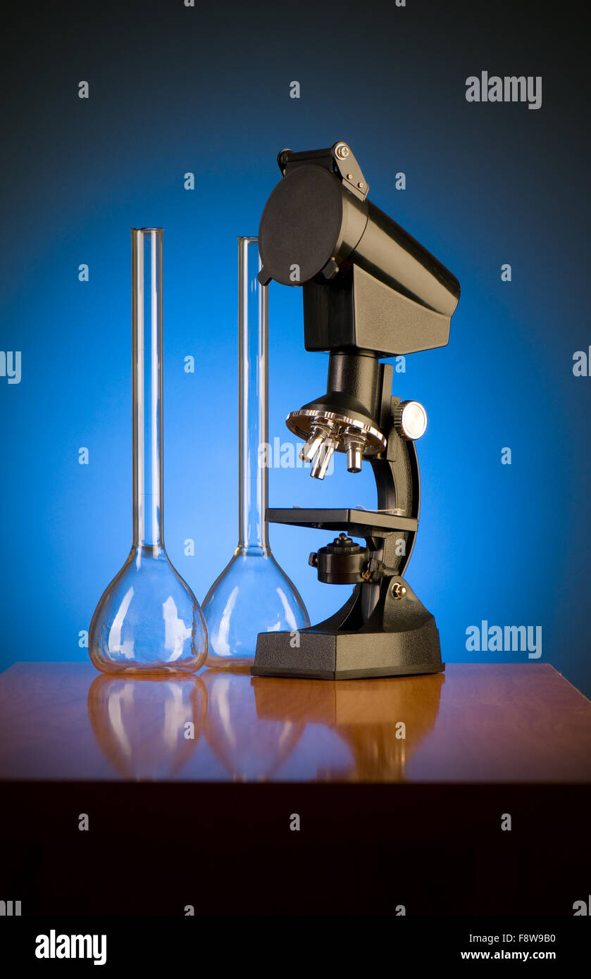 Microscope against blue gradient background Stock Photo - Alamy