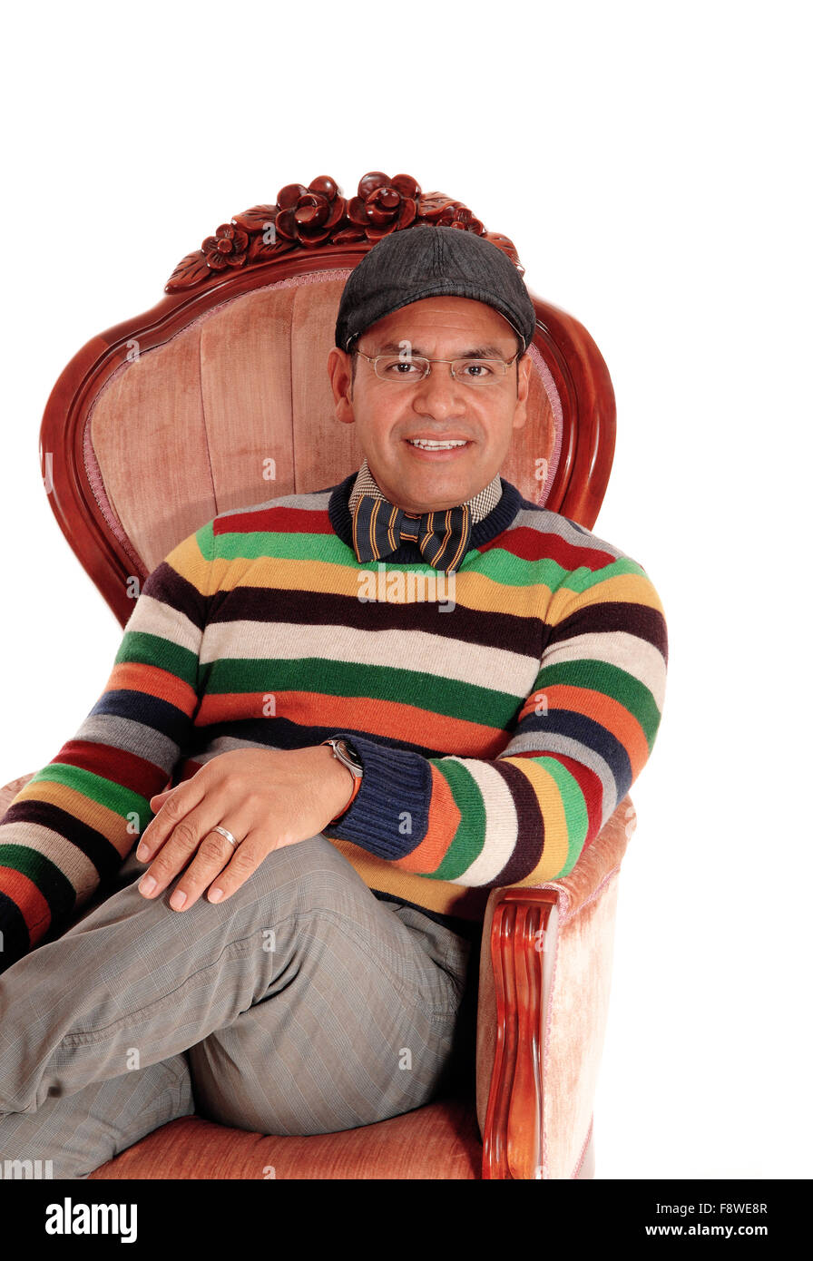 A happy Hispanic man with a bow tie and cap sitting relaxing in a ...