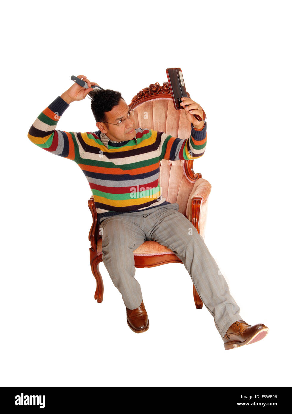 A middle age Hispanic man is very idle with his hair and coming it very ...