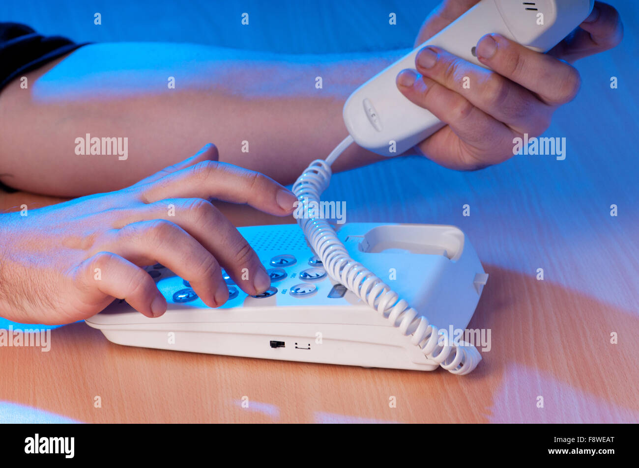 Hands dialing phone buttons in the darkness Stock Photo - Alamy