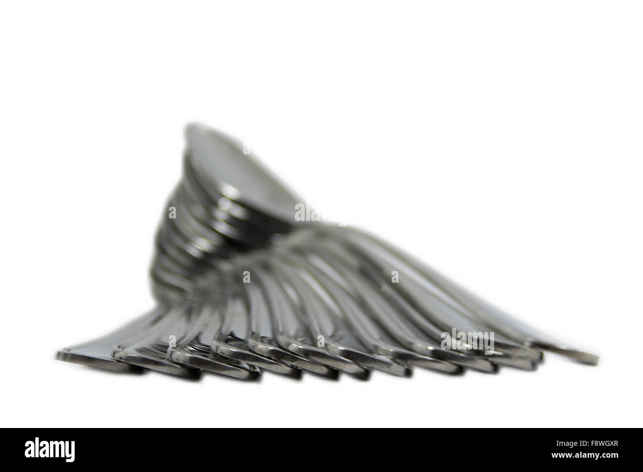Pile of Spoons facing away isolated Stock Photo - Alamy