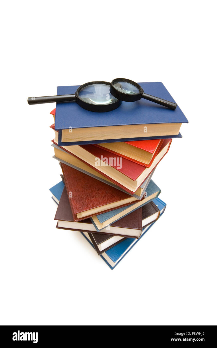 Magnifying glass over the stack of books Stock Photo - Alamy