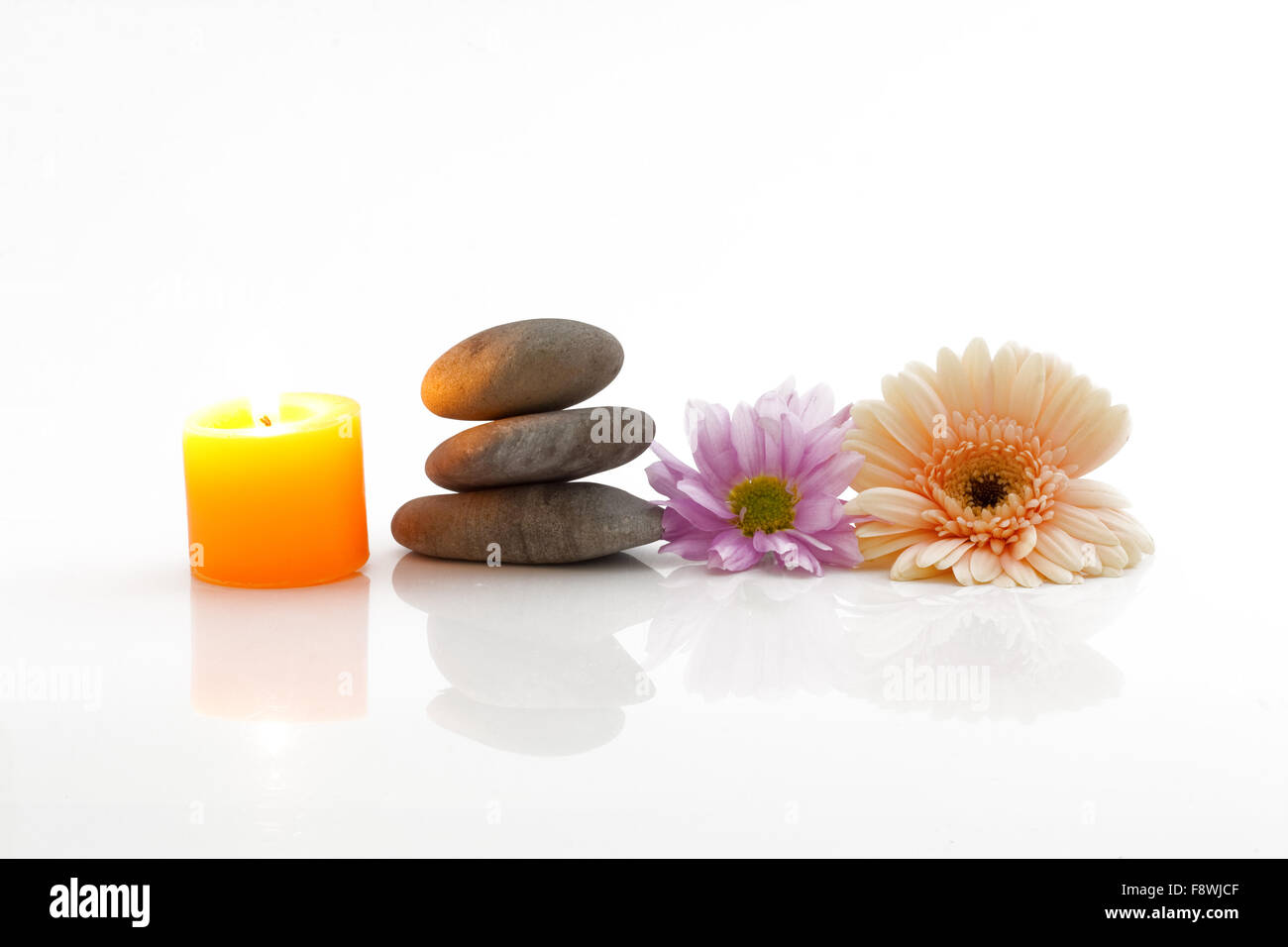 Flowers, candle, stones - spa theme Stock Photo - Alamy