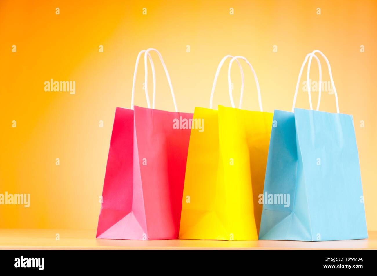 Colourful paper shopping bags against gradient background Stock Photo ...