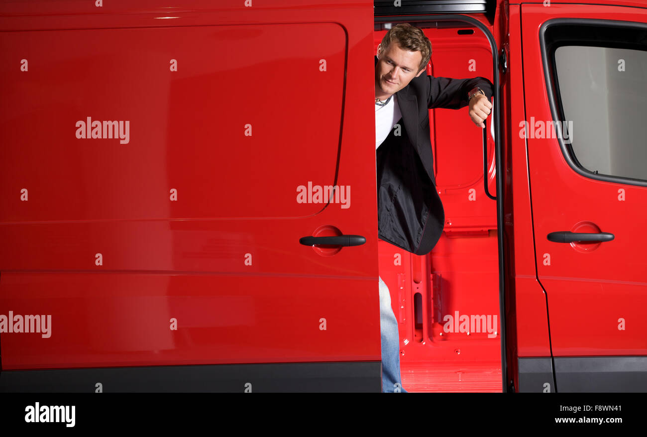 Young man looking through van door Stock Photo - Alamy