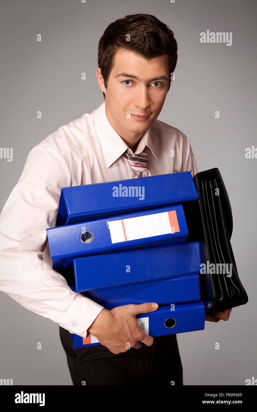 Young caucasian businessman holding a stack of binders Stock Photo - Alamy