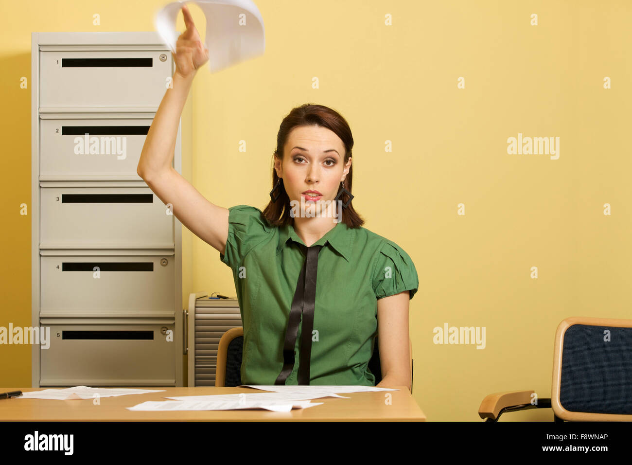 Portrait of businesswoman throwing document at office Stock Photo - Alamy