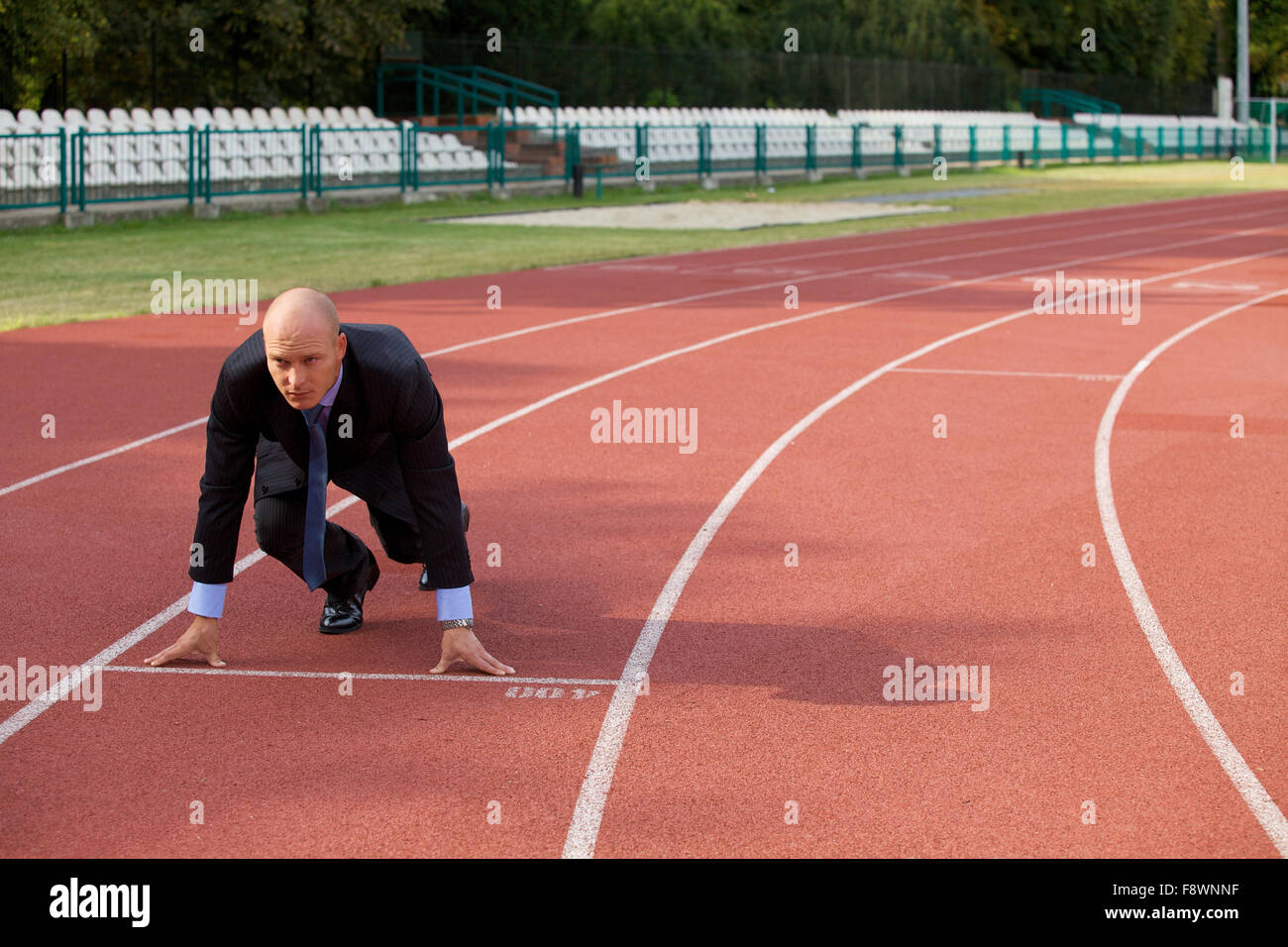 Businessman at the start line of running track Stock Photo - Alamy