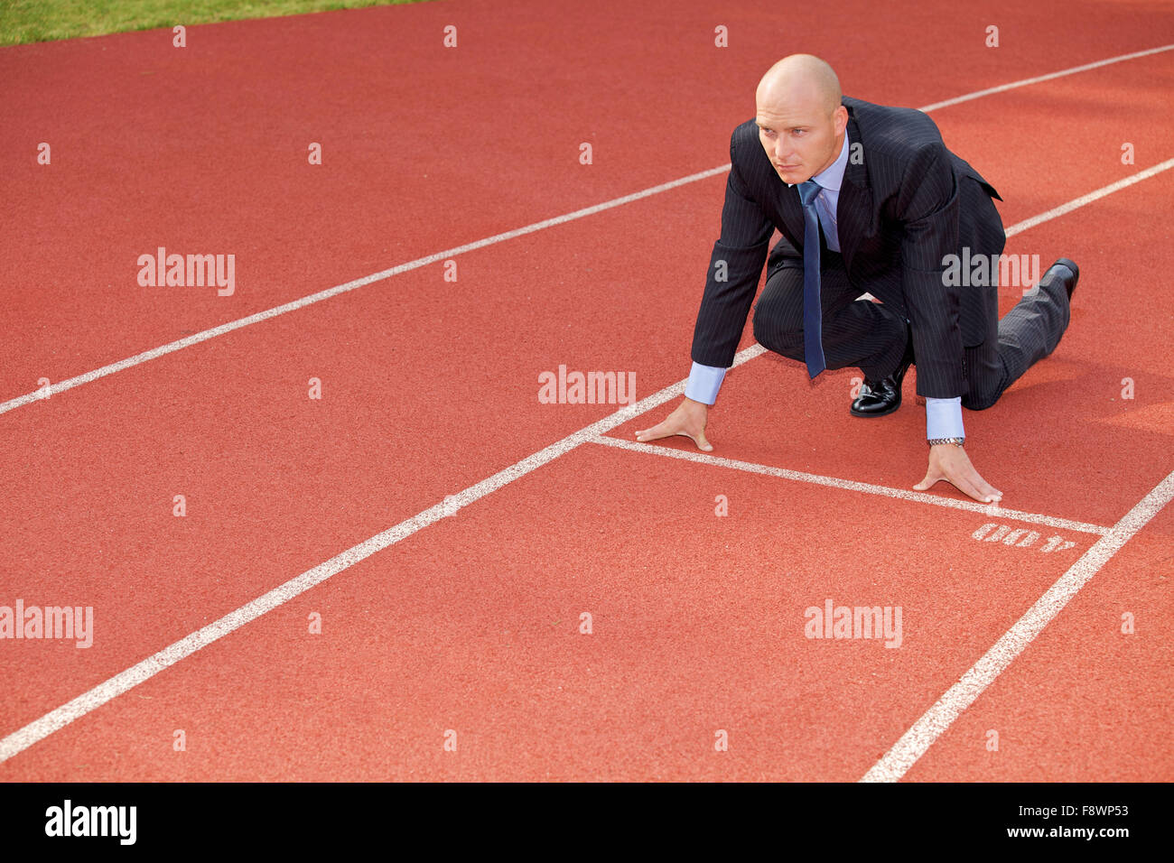 Businessman at the start line of running track Stock Photo - Alamy