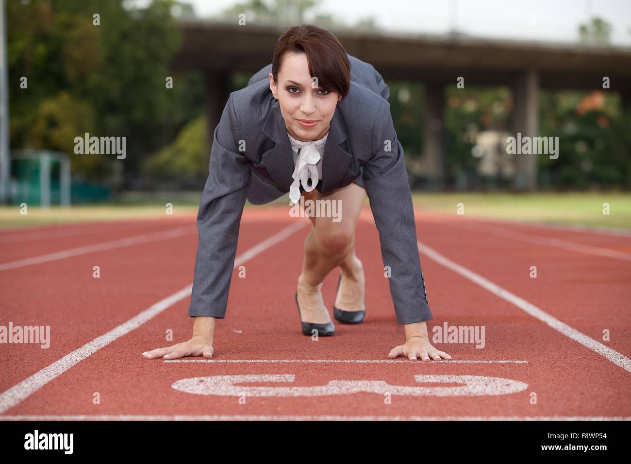 Businesswoman on start line of a running track Stock Photo - Alamy
