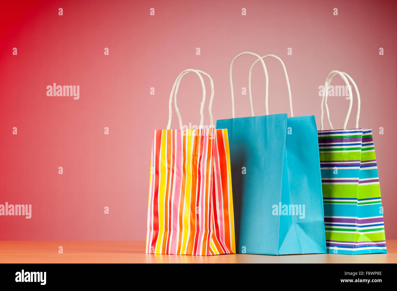 Colourful paper shopping bags against gradient background Stock Photo ...